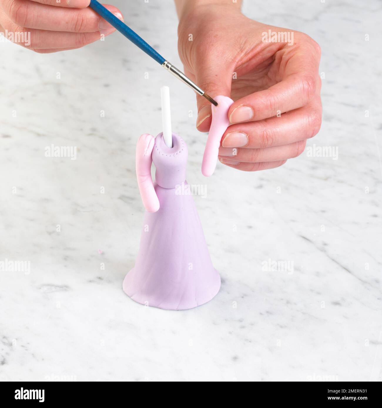 Attaching arm to lady made of fondant icing Stock Photo - Alamy