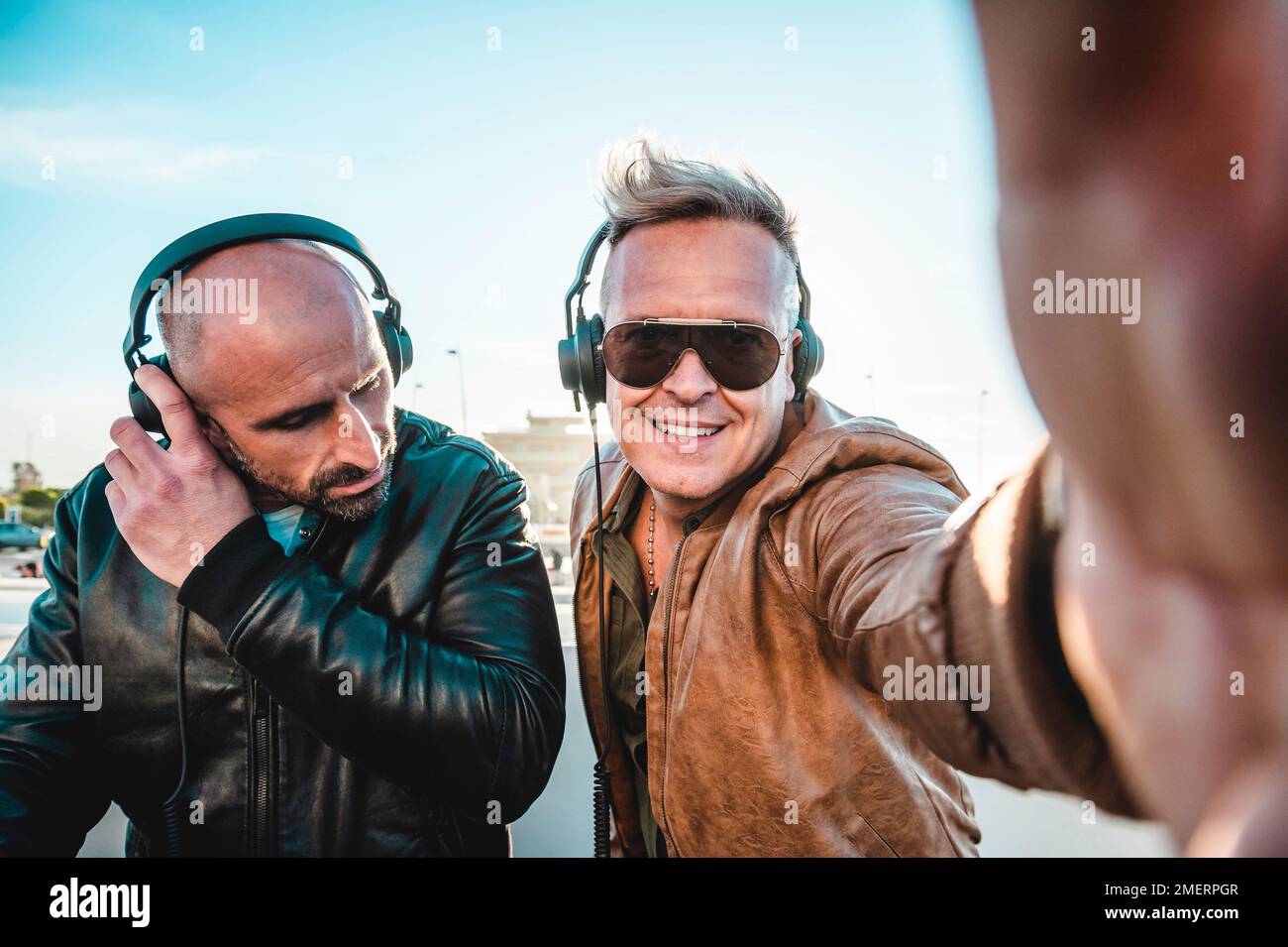 Disc jockeys having fun doing selfie while playing music for tourist ...