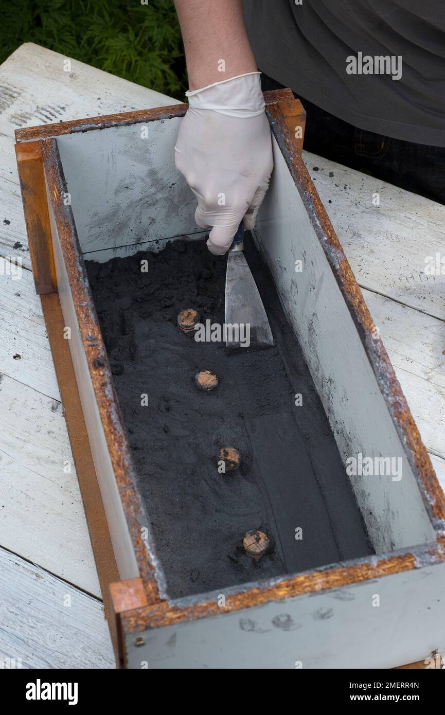 Making concrete planter, building a base layer of concrete Stock Photo ...