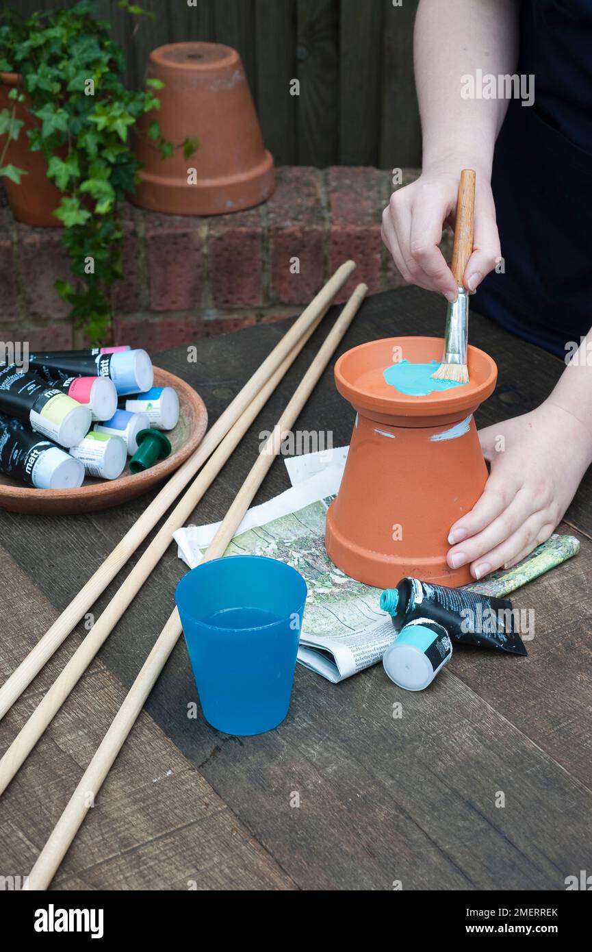 Painting drip tray blue, table containing cane, paints and water Stock ...