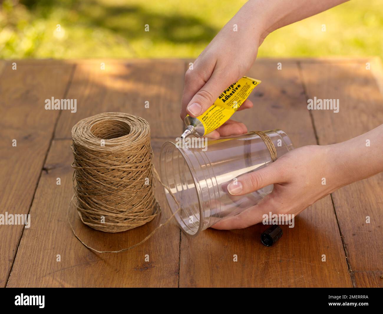 Winding twine around a pot and gluing in place Stock Photo - Alamy