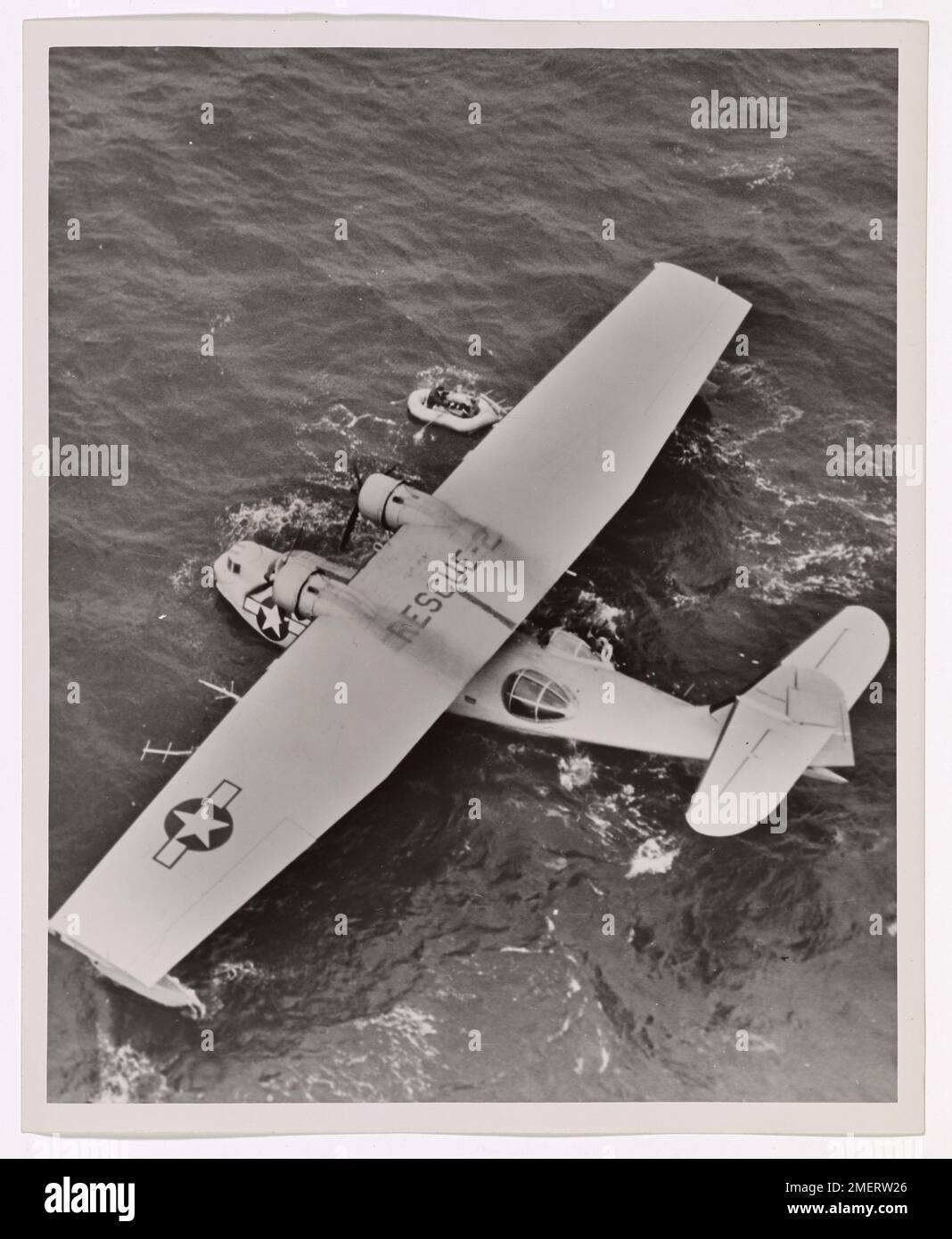 A Coast Guard plane performs a rescue mission for survivors of the USS ...