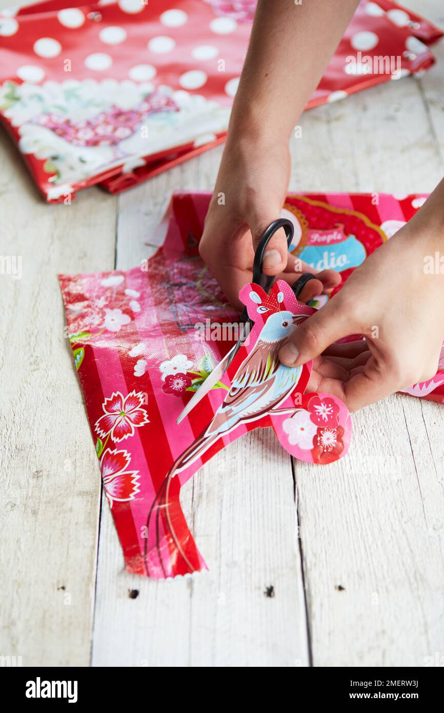 Cutting out bird motif to attach to oilcloth saddle bag planter Stock ...