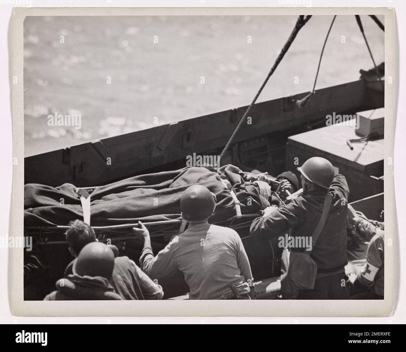 Coast Guardsmen aboard an assault transport assist in transferring ...