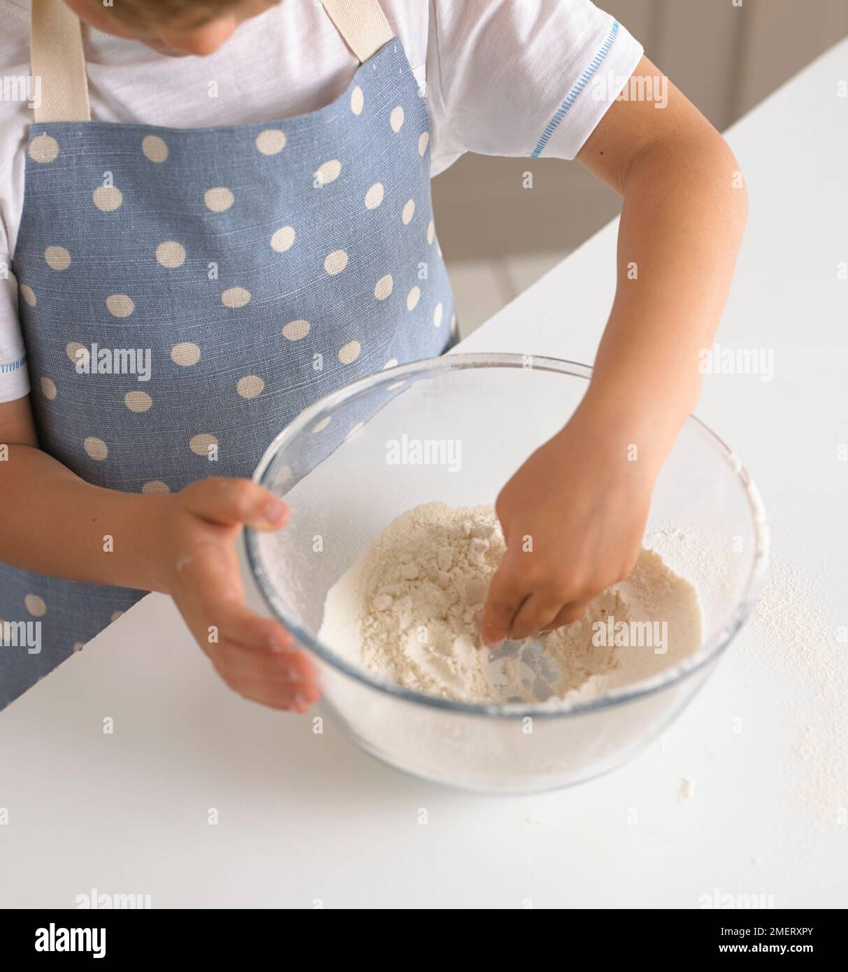 Boy making well in bowl of flour, 6 years Stock Photo - Alamy
