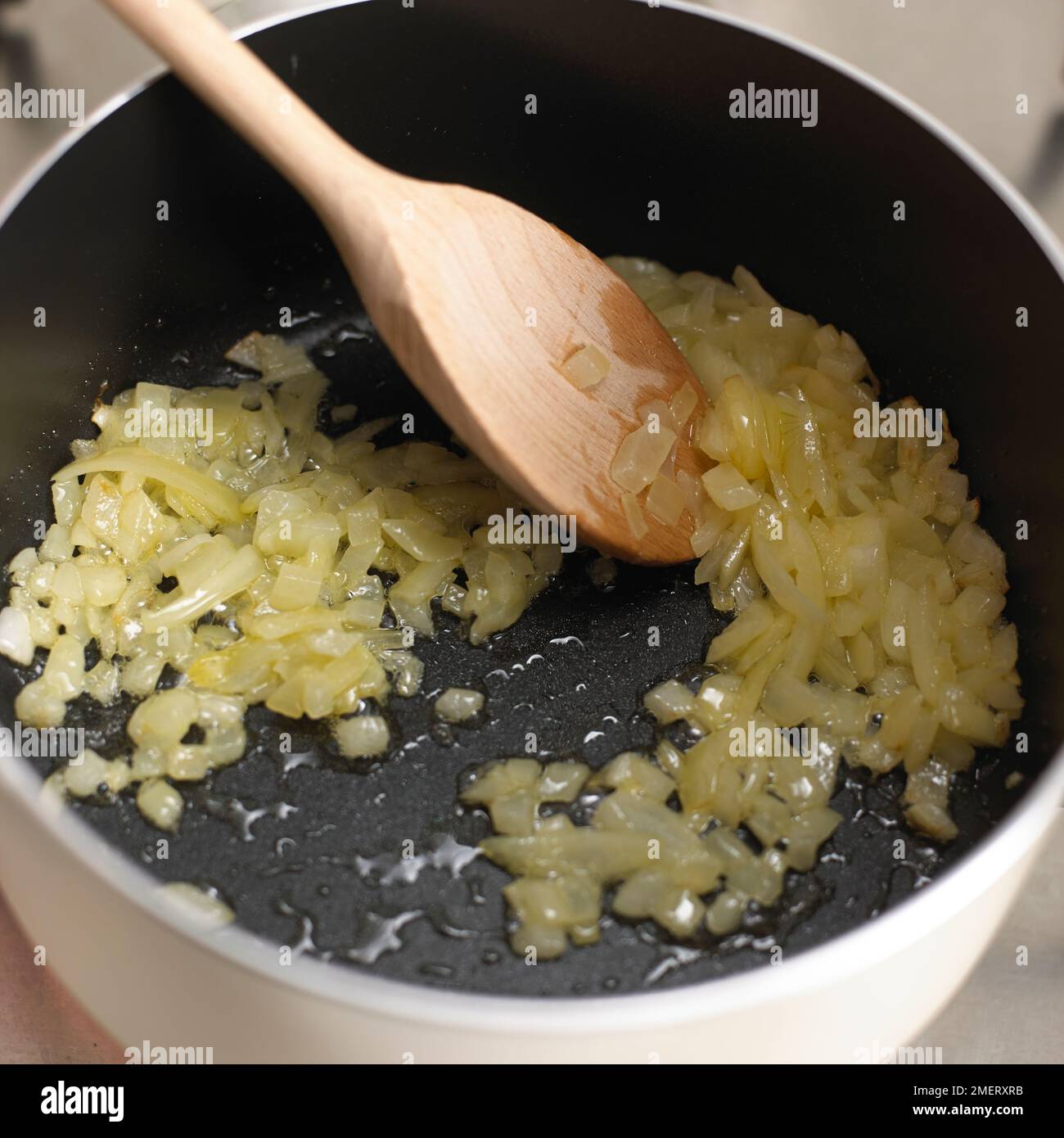 Frying chopped onion in a saucepan Stock Photo - Alamy