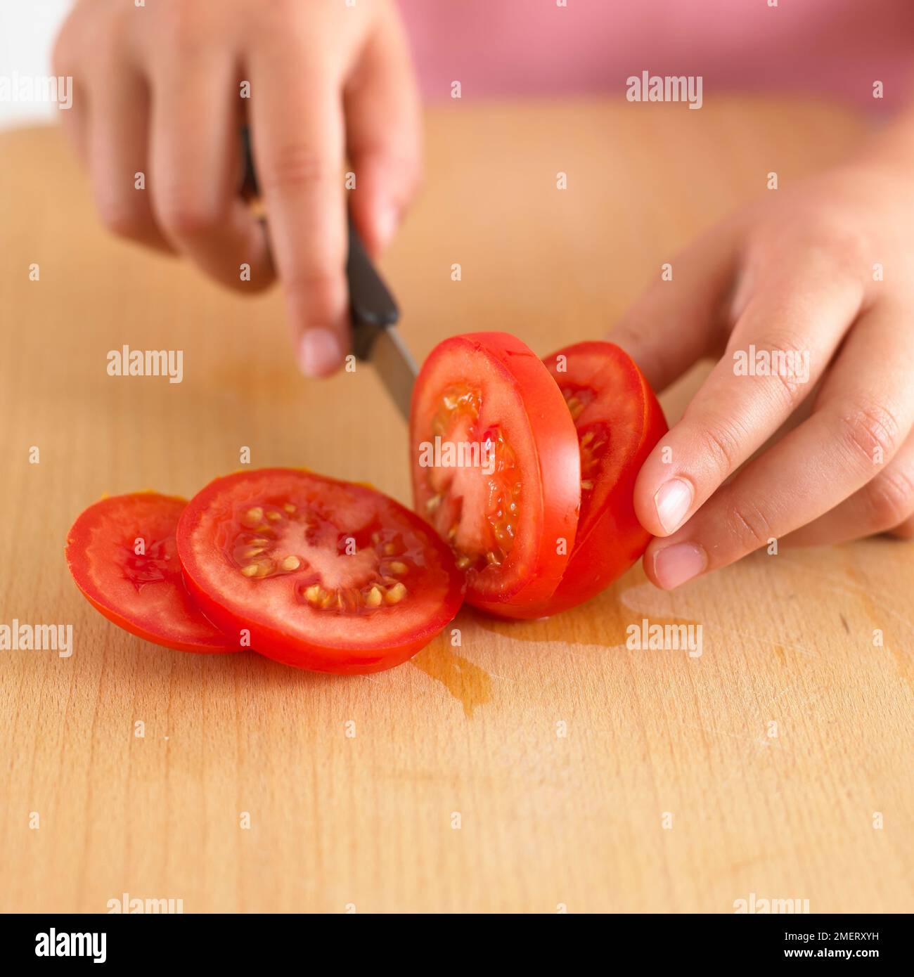 Hand slicing red tomato knife hi-res stock photography and images - Alamy