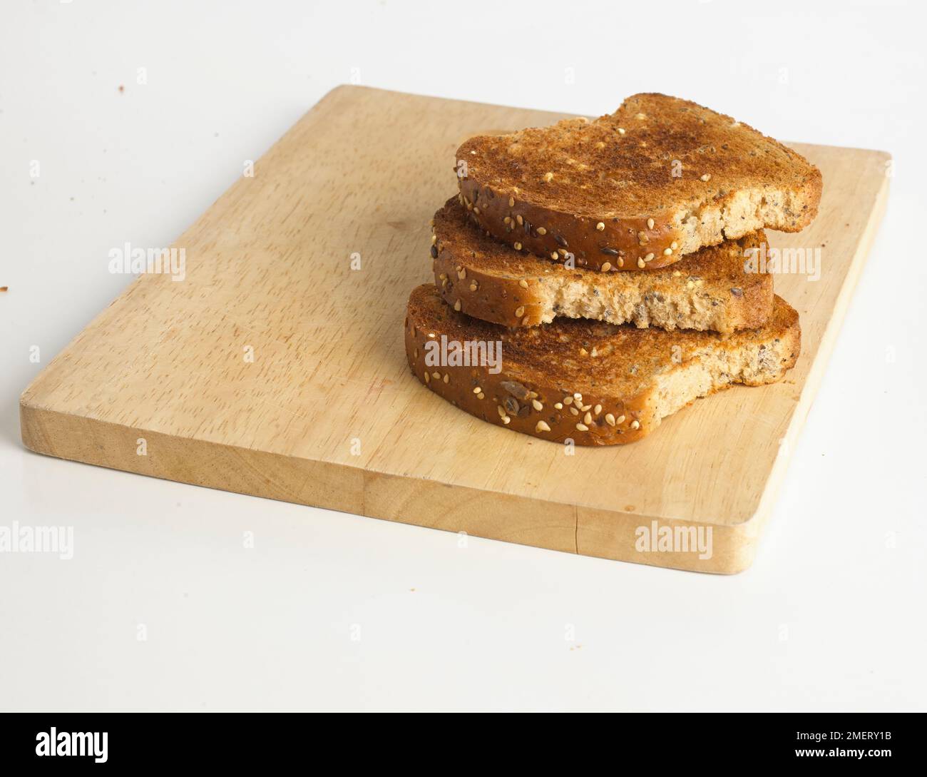 Three slices of seeded toast on breadboard Stock Photo - Alamy