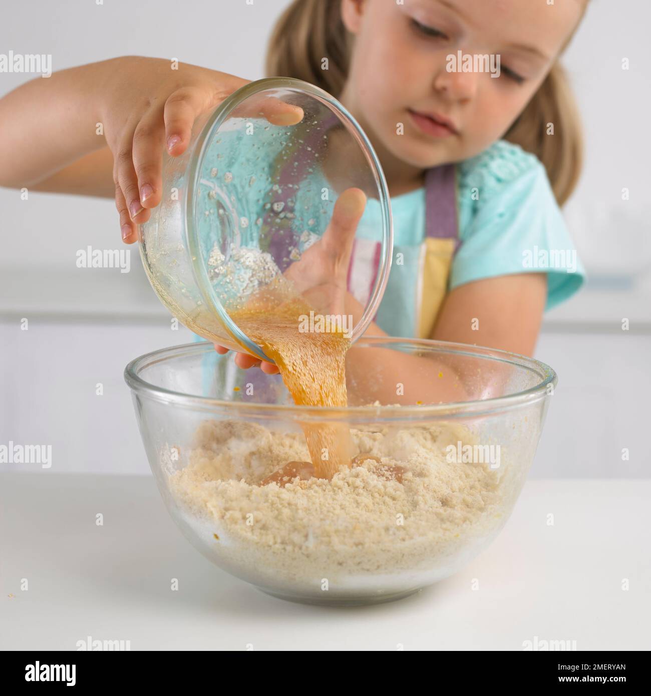 Adding egg and golden syrup mixture to bowl, making cookie dough Stock ...