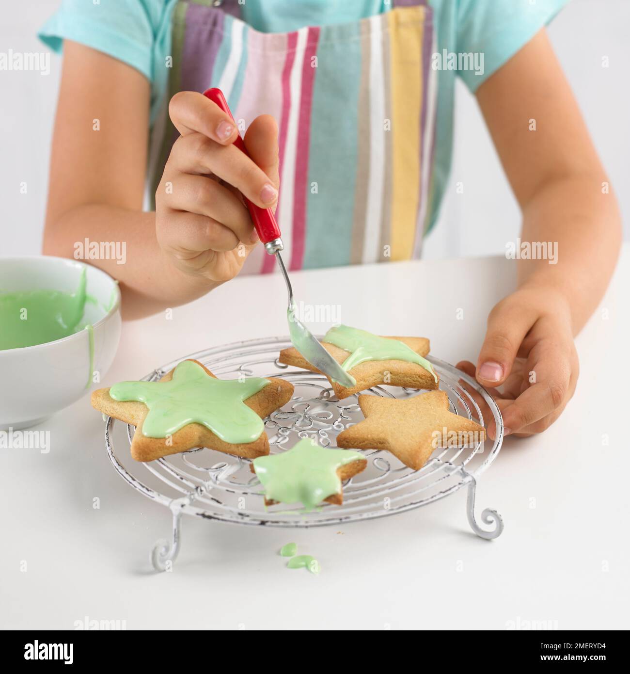 Girl decorating star shaped cookies with icing Stock Photo - Alamy