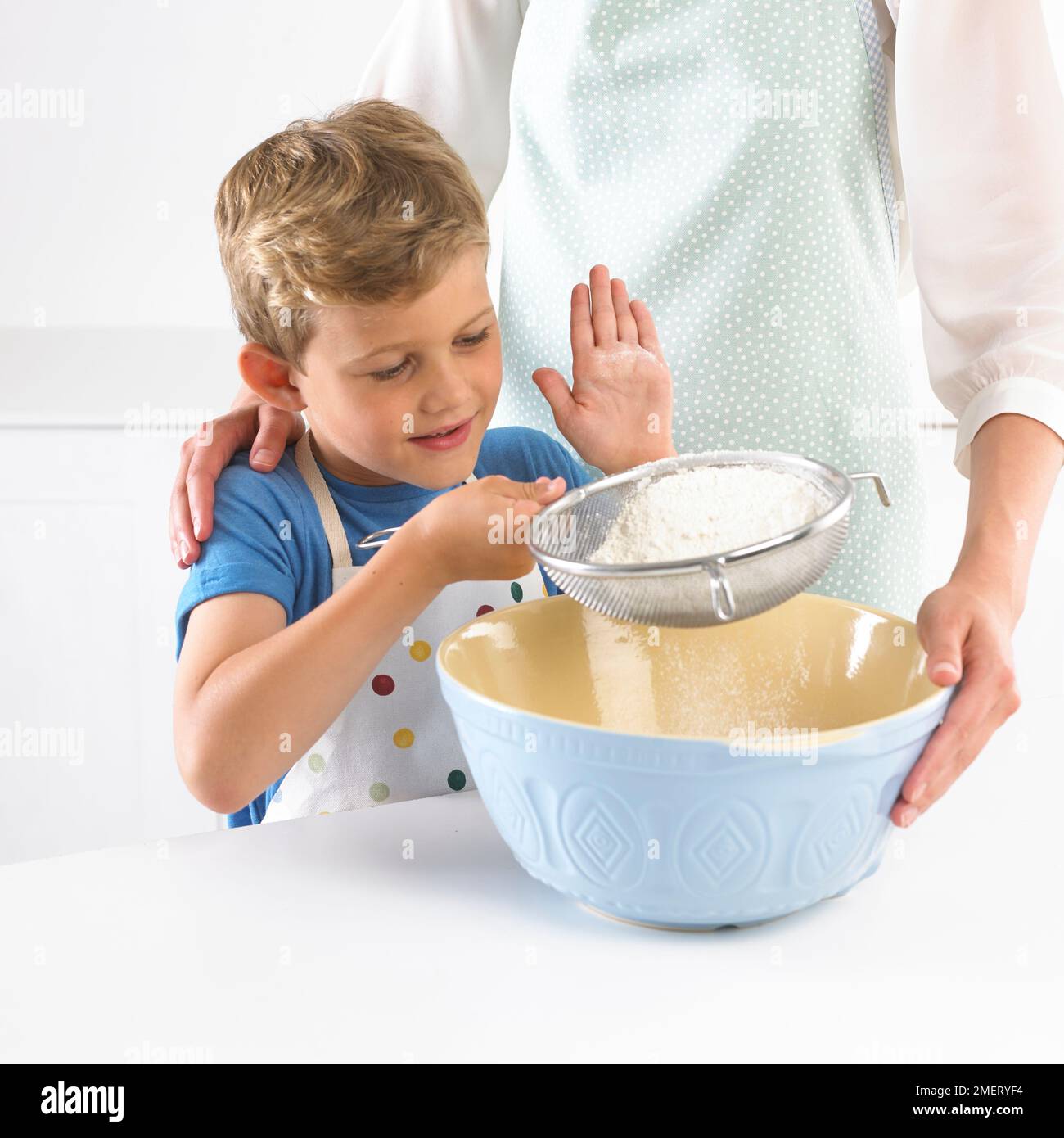 Boy sieving flour into a mixing bowl, 6 years Stock Photo - Alamy