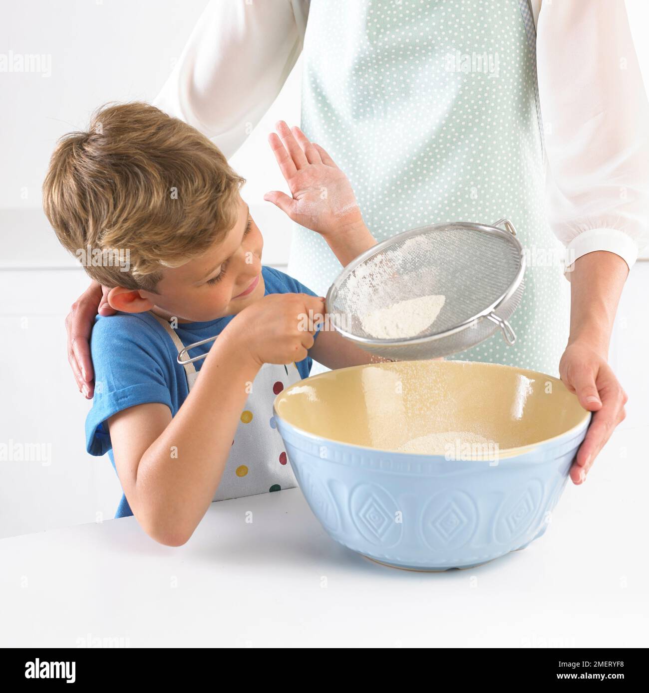 Boy sieving flour into a mixing bowl, 6 years Stock Photo - Alamy