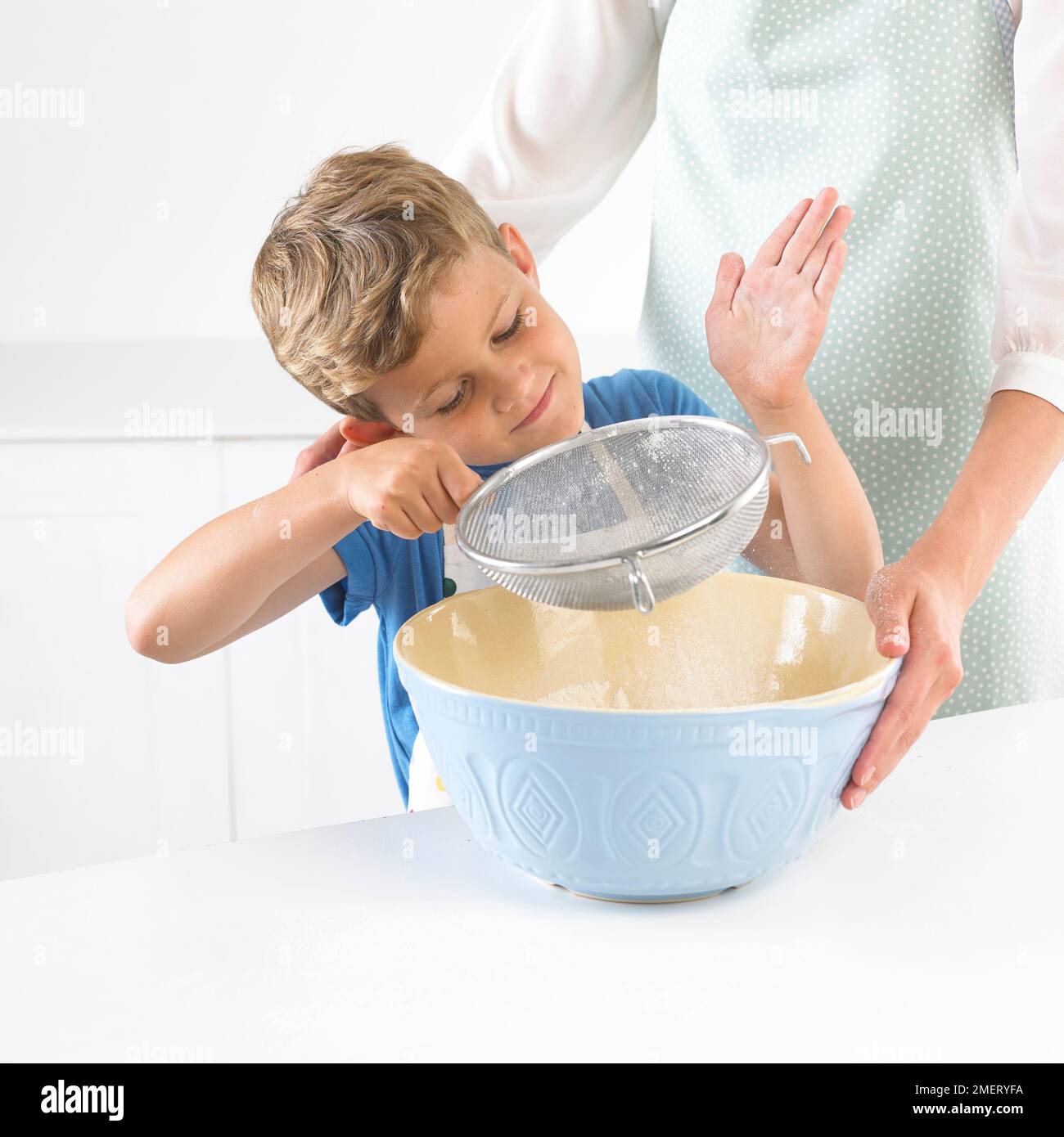 Boy sieving flour into a mixing bowl, 6 years Stock Photo - Alamy