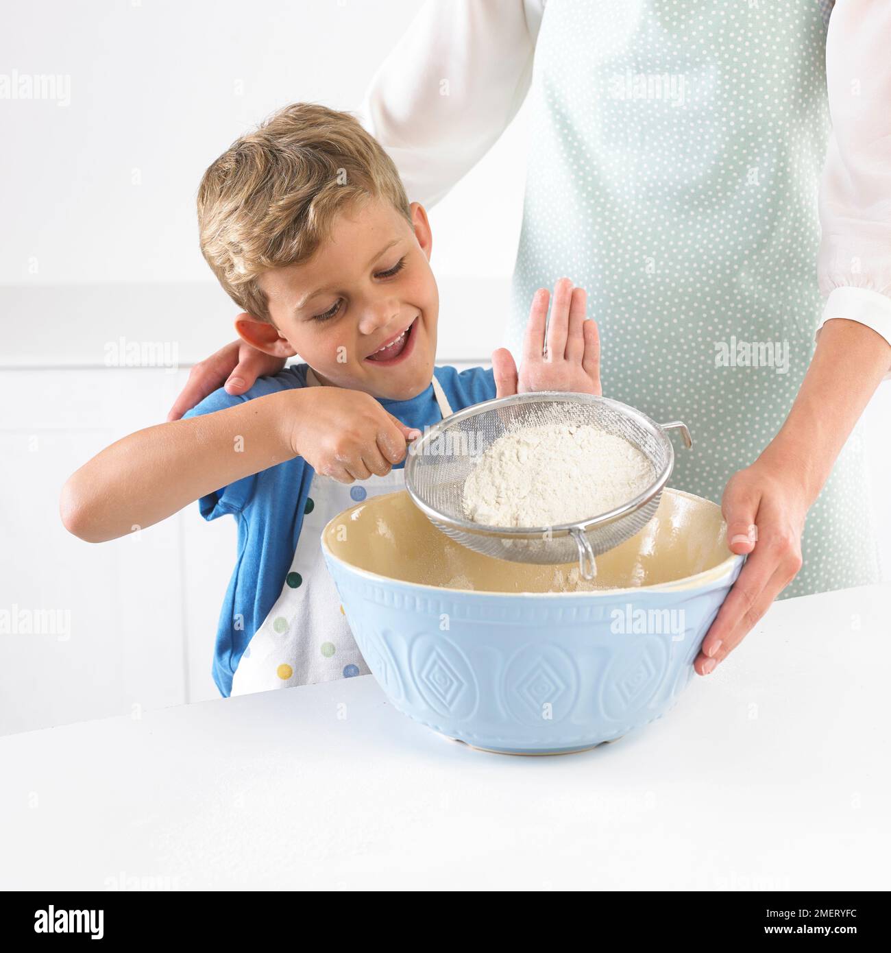 Boy sieving flour into a mixing bowl, 6 years Stock Photo - Alamy