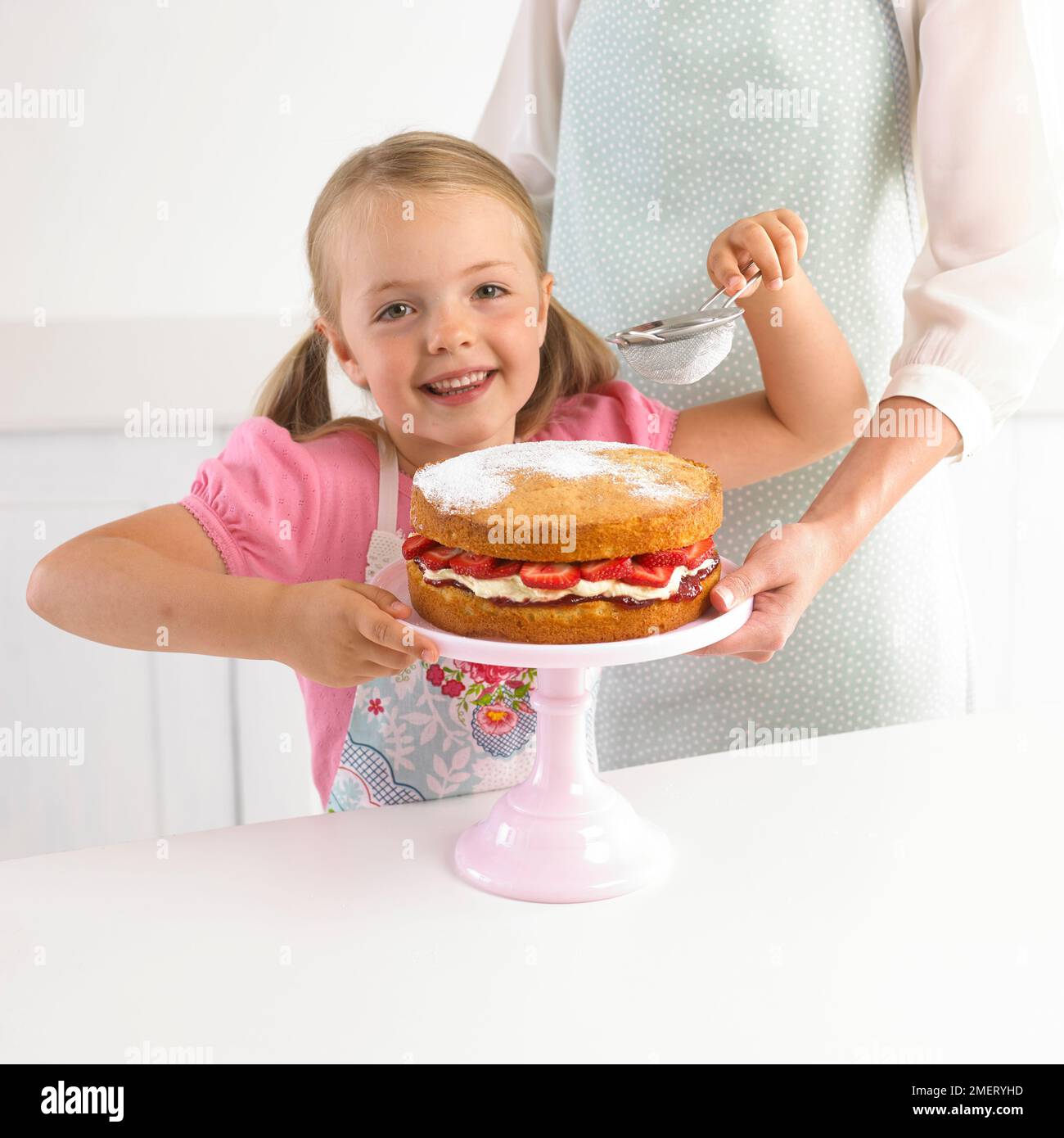 Sieving icing sugar over strawberry sponge cake, 5 years Stock Photo ...