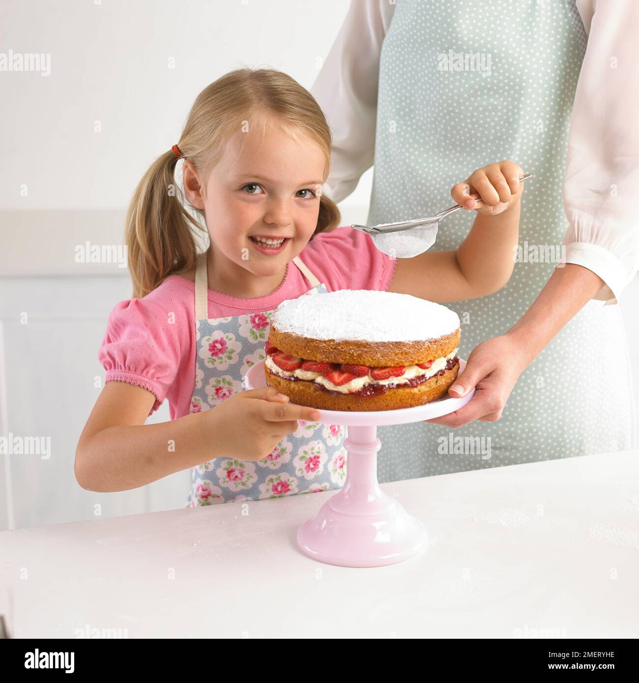 Sieving icing sugar over strawberry sponge cake, 5 years Stock Photo ...