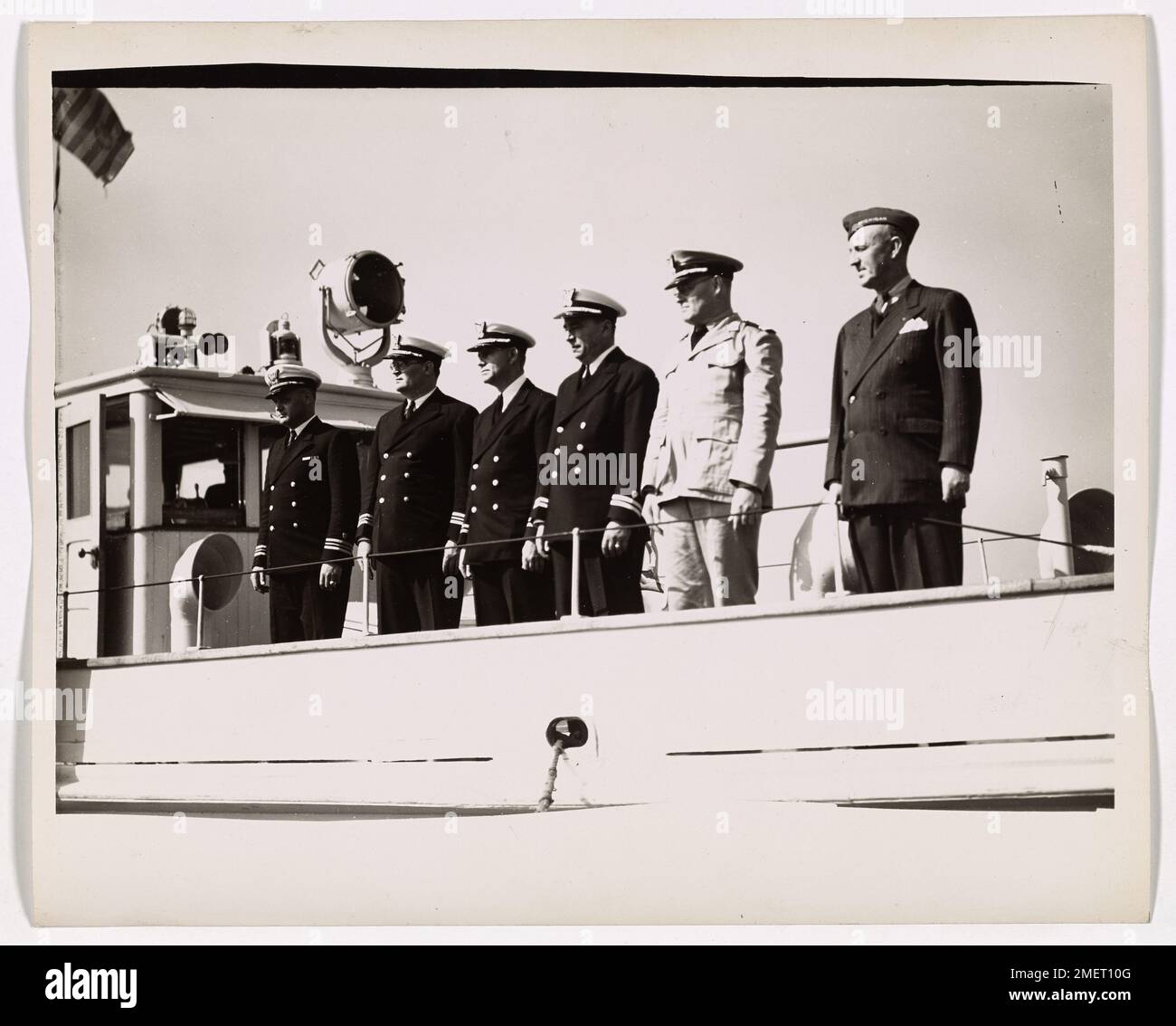 A group of U.S. Coast Guard officers are shown in uniform, standing ...