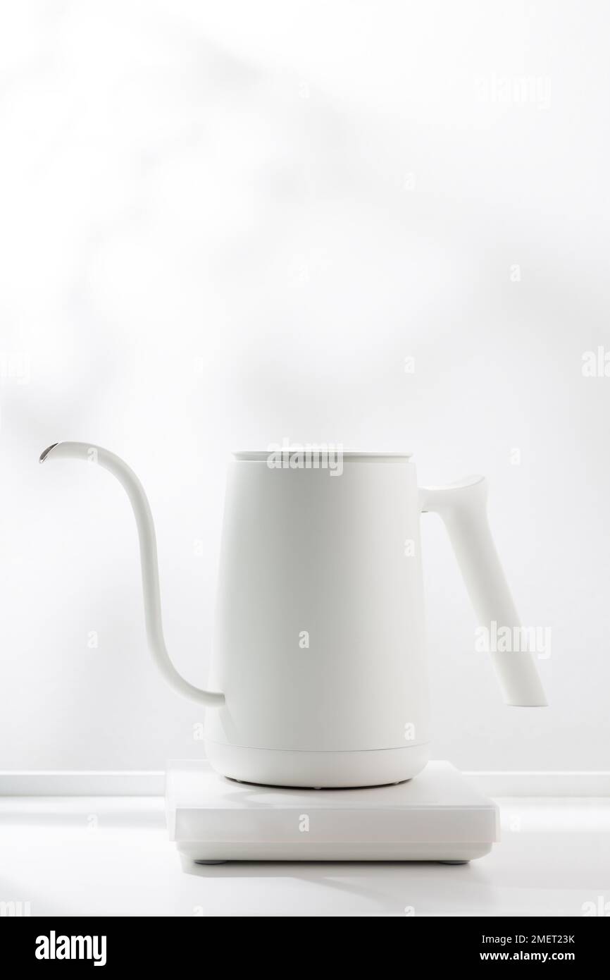 Minimalist white electric kettle on a white table Stock Photo - Alamy