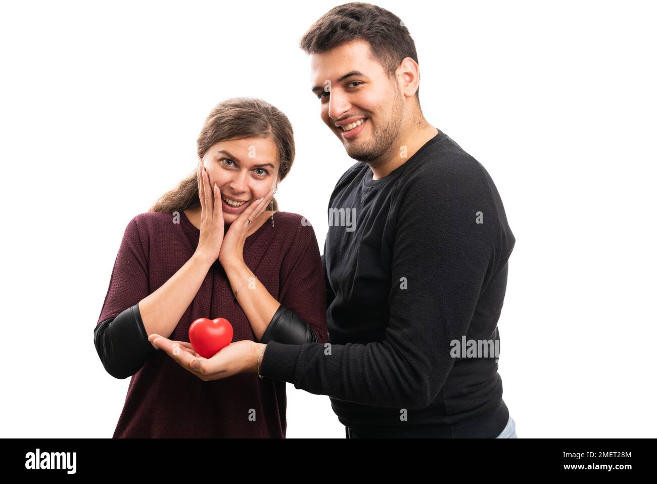 Smiling boyfriend offering red heart to cute girlfriend with love ...
