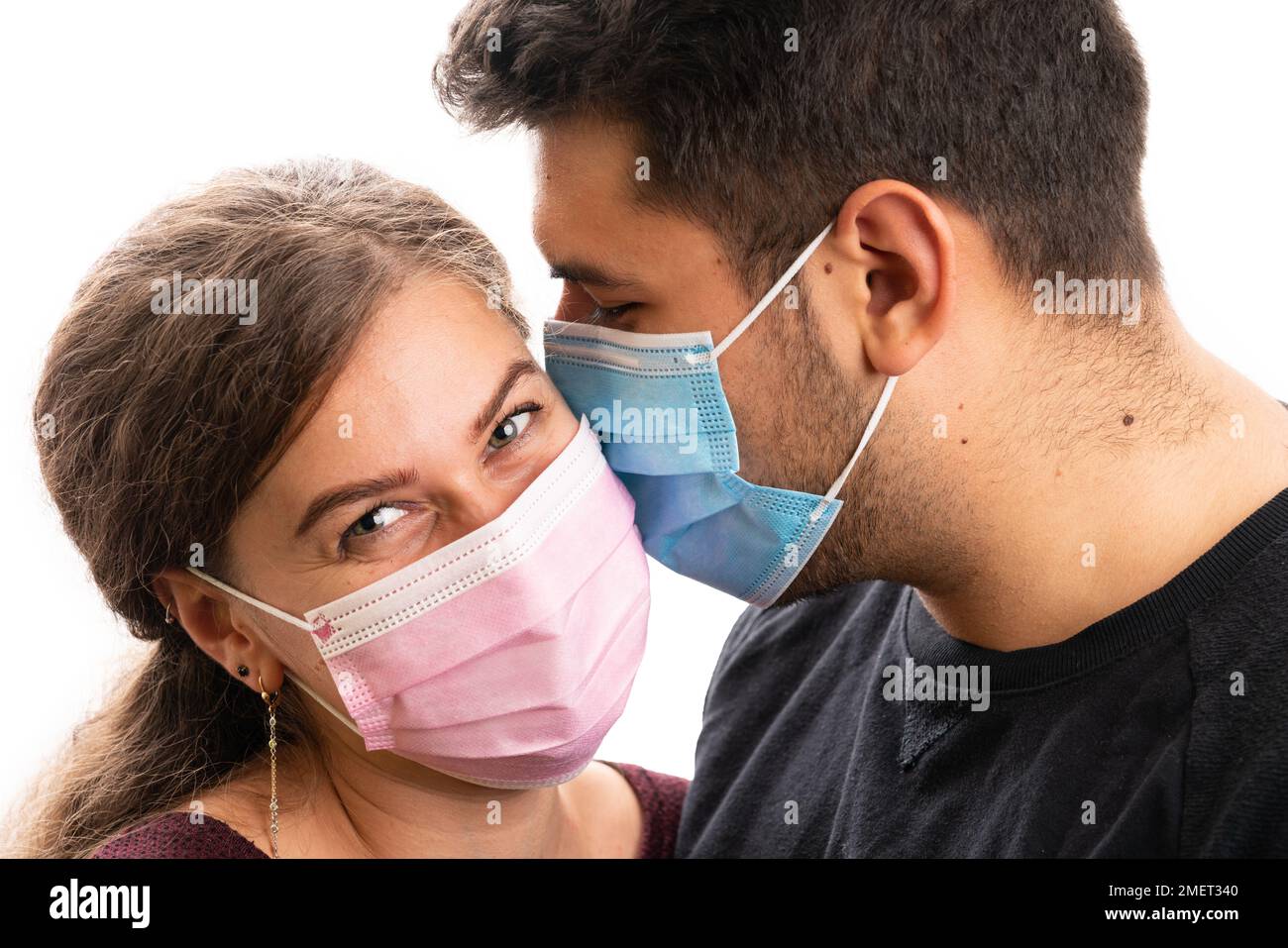 Close-up of loving boyfriend kissing girlfriend on cheek wearing blue ...