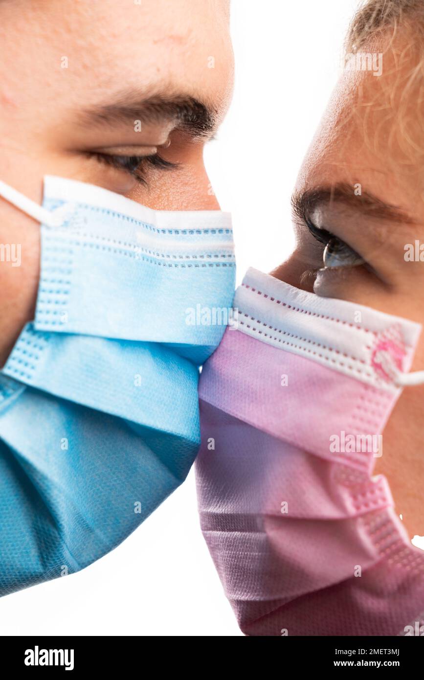 Close-up of man and woman romantic couple kissing through medical or ...