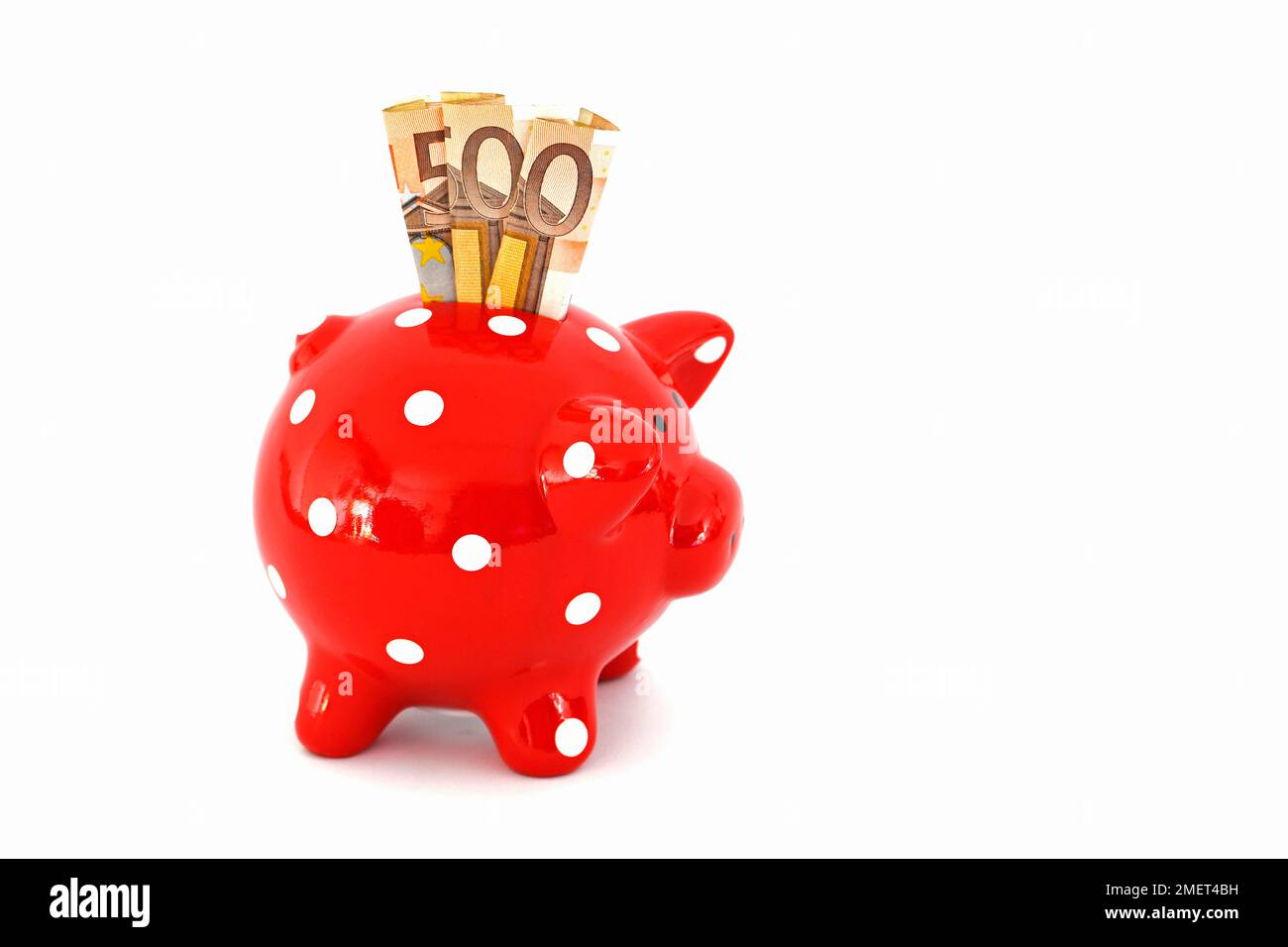 Red piggy bank with white dots and 50 euro banknotes, cropped, cutout ...