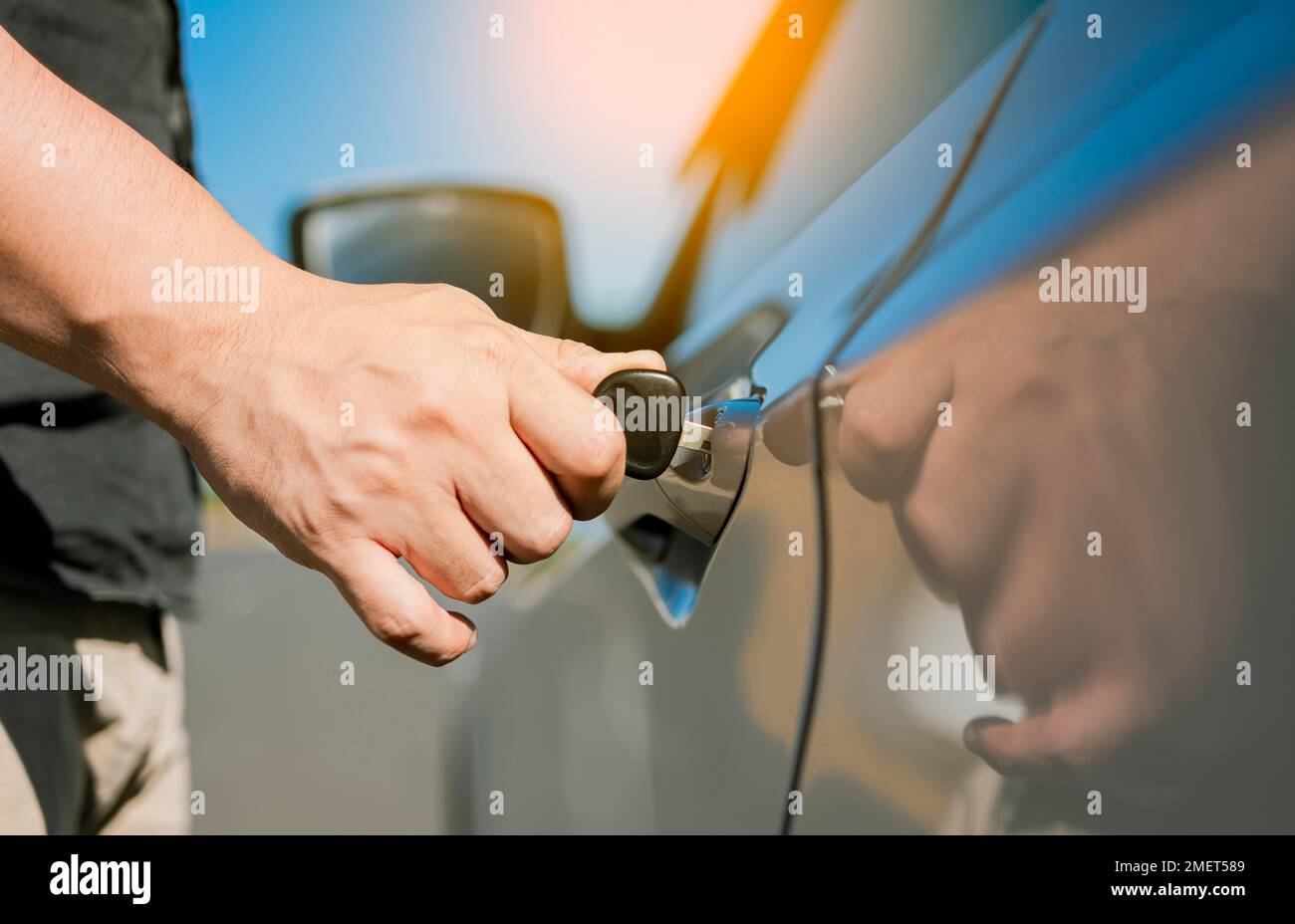 Hands with keys opening the car door. Close-up of hands opening the car ...