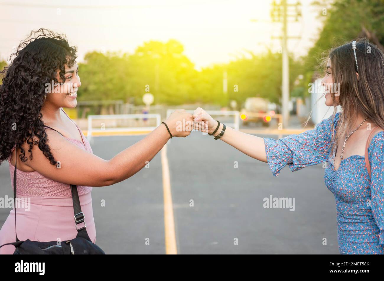 Two women greet each other friendly with fists Stock Photo - Alamy