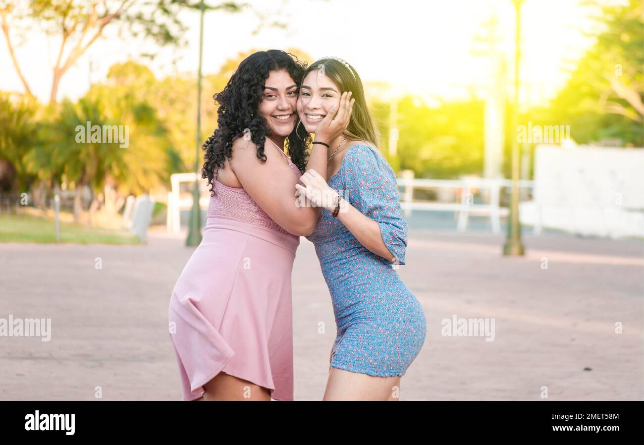 Two female friends hugging in front outdoors, girl friends hugging and ...