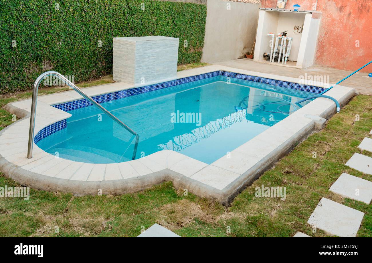 A blue swimming pool with a sand suction hose. A swimming pool with ...