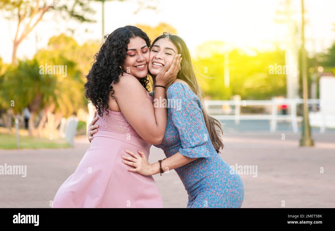 Two female friends hugging in front outdoors, girl friends hugging and enjoying life, women ...