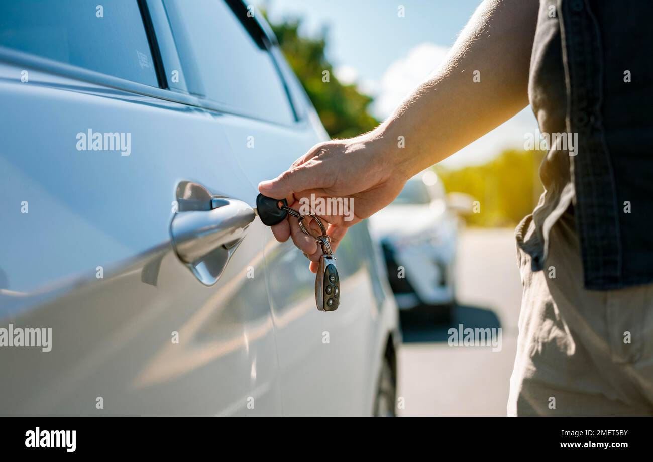 Vehicle owner opening the door with the keys. Hands with keys opening ...