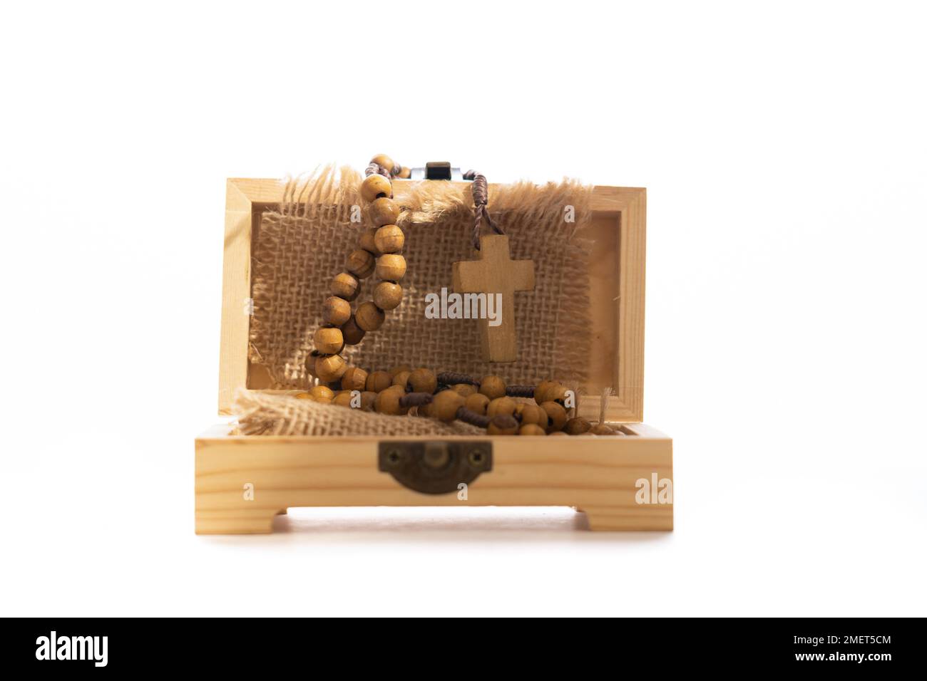 Wooden christian rosary in a box with raffia white background and copy ...