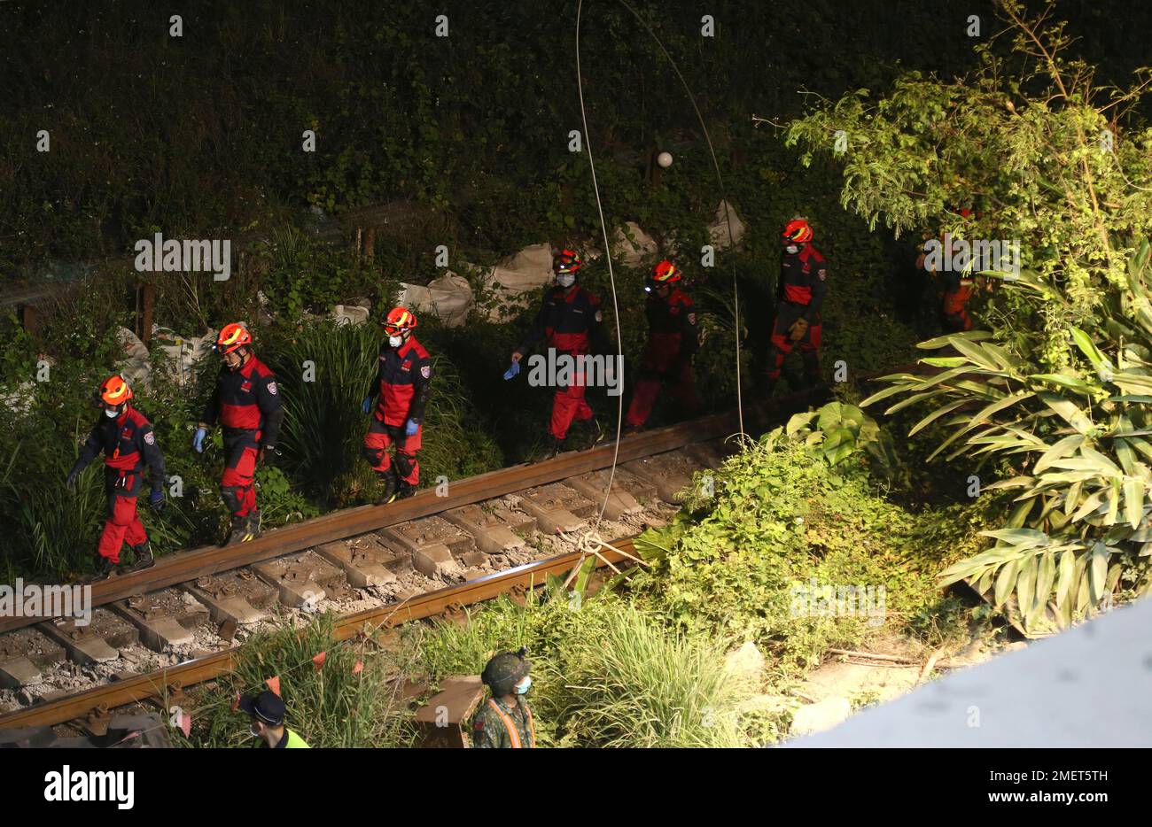 A team of rescue workers change shift from working on the derailed train near the Taroko Gorge ...