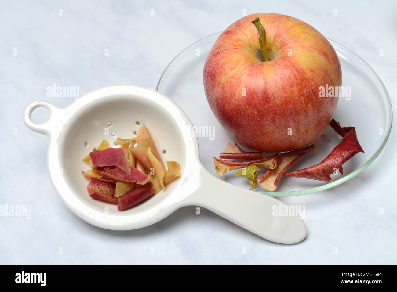 Apple peel tea in tea strainer and apple, tea Stock Photo - Alamy