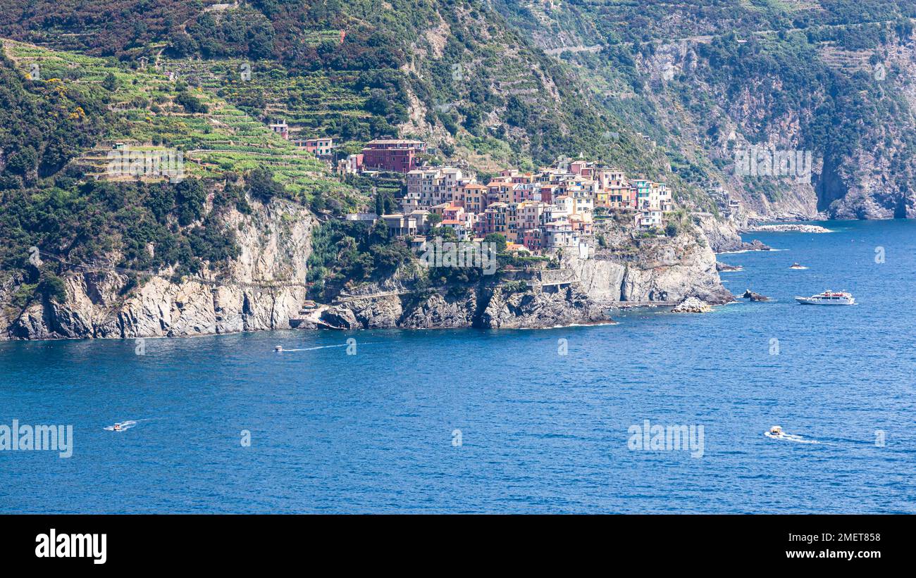 The village of Manarola with its nested pastel-coloured houses built ...