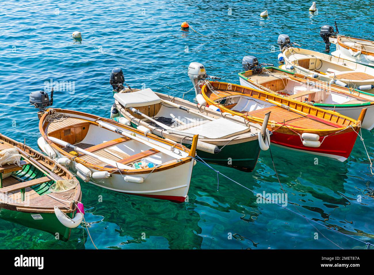 Colourful fishing boats reflected in the water in the harbour of ...