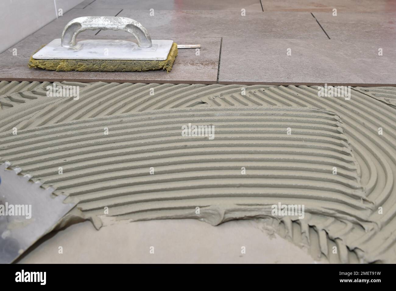Tiler has applied tile adhesive to floor, Hesse, Germany Stock Photo ...