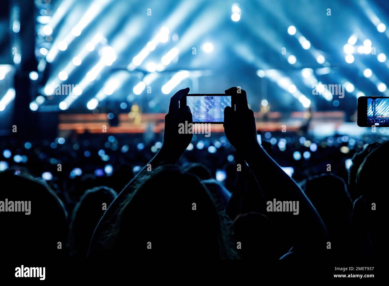 Making video of concert using a smartphone. Cheering people on an ...