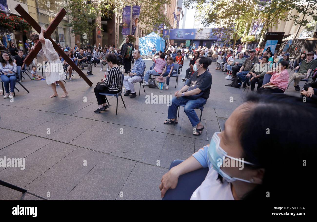 Actor Timothy Watkins carries a cross during his portrayal of Jesus ...