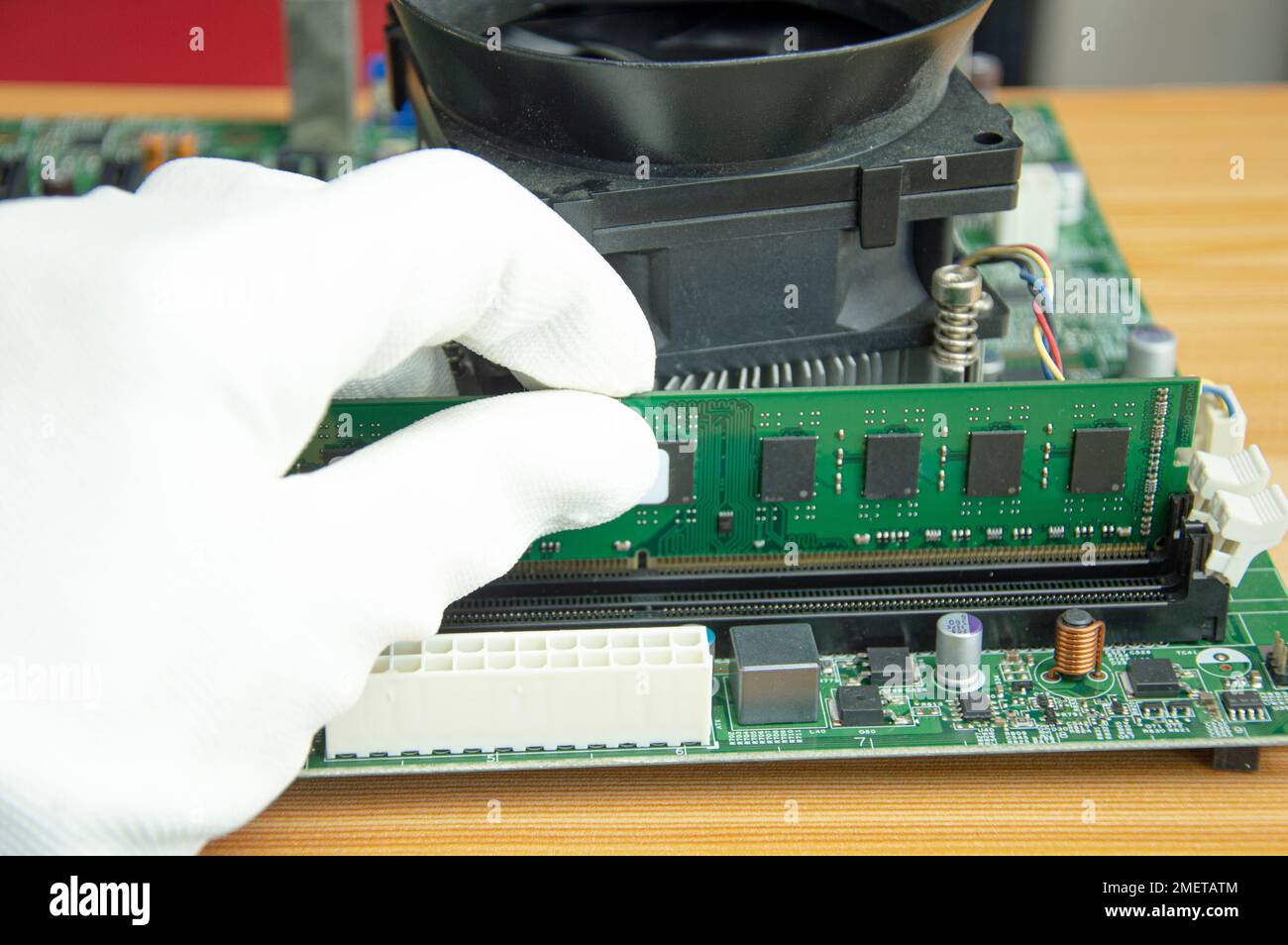 Side view of a technician clearing the RAM of a computer motherboard ...