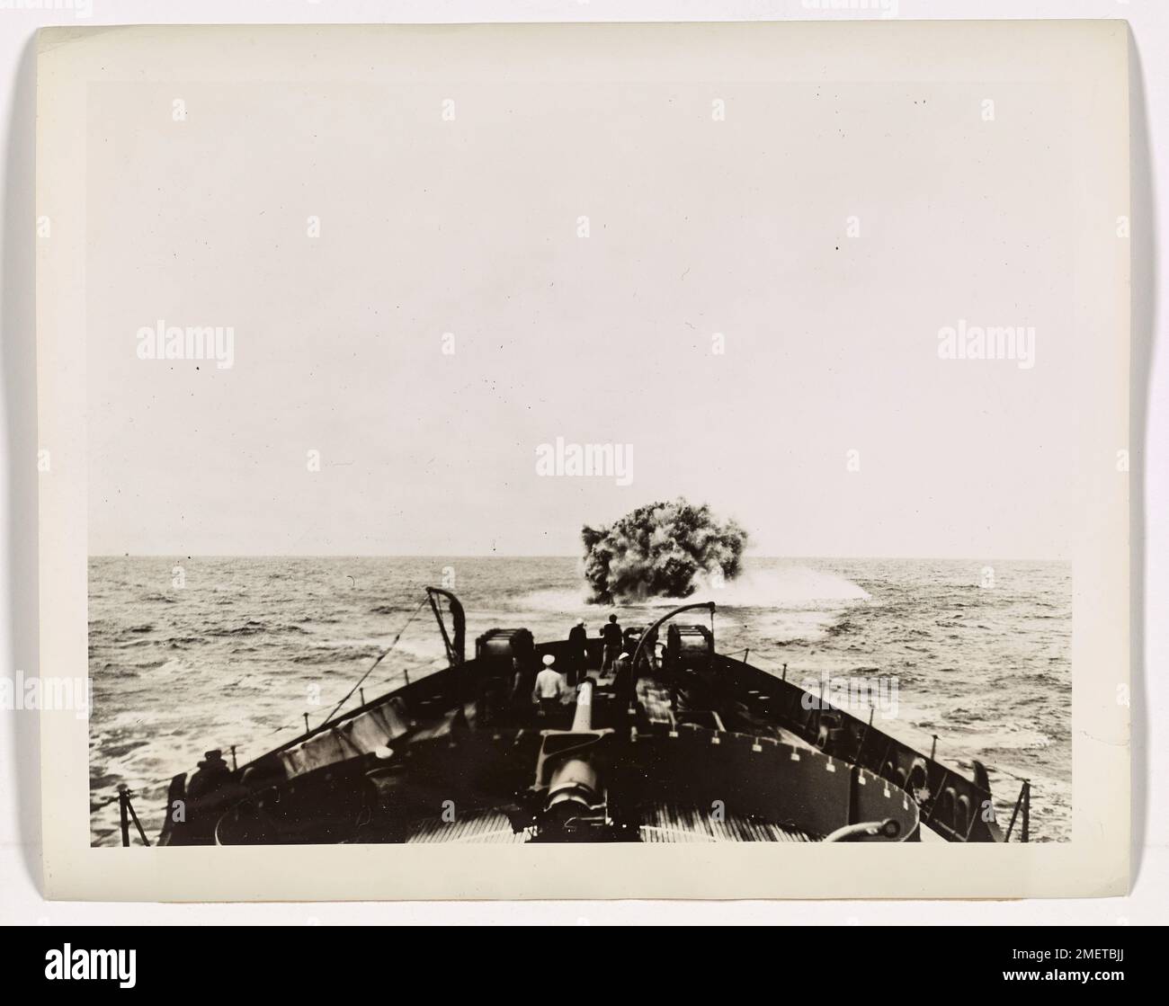 The image shows a U.S. Coast Guard cutter dropping a depth charge ...