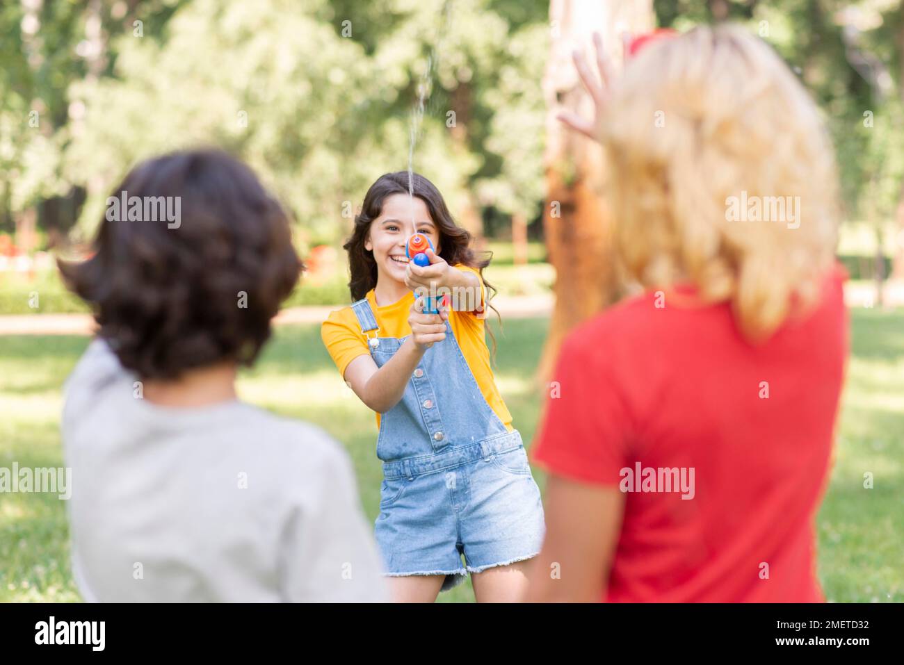 Childrens park playing with water gun Stock Photo - Alamy