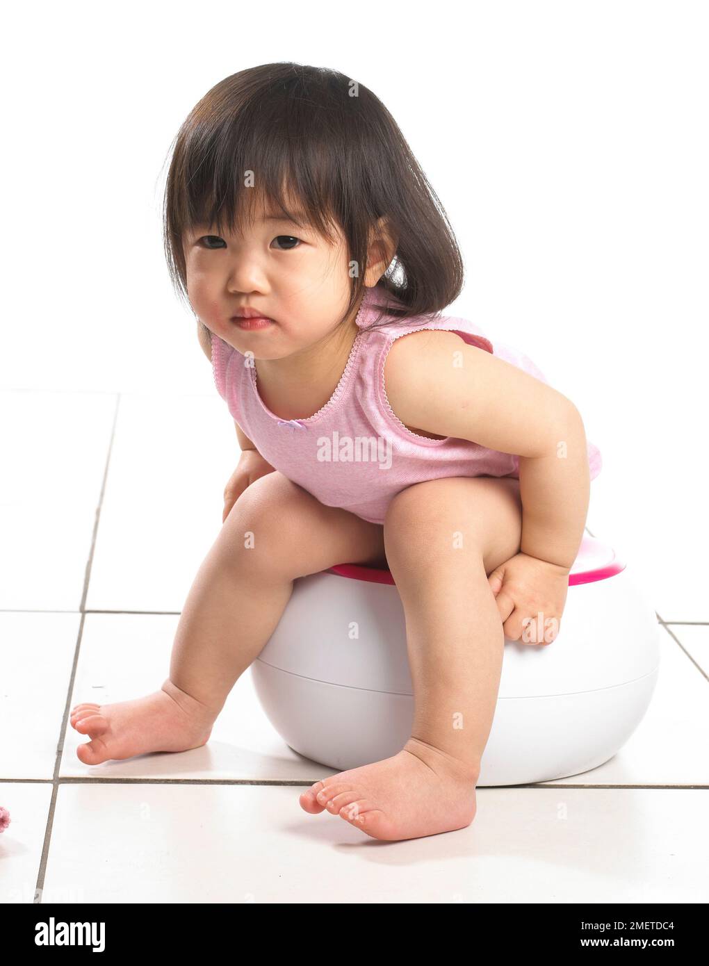 Girl wearing pink vest sitting on white potty, 20 months Stock Photo - Alamy