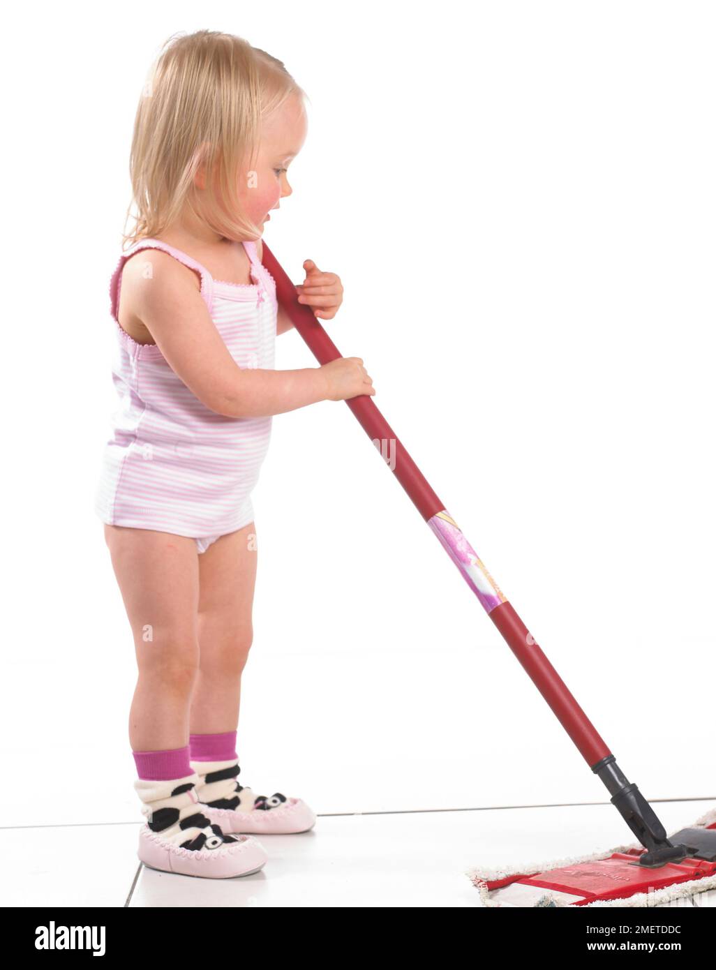 Girl wearing vest, pants and slippers using a mop, 20 months Stock ...