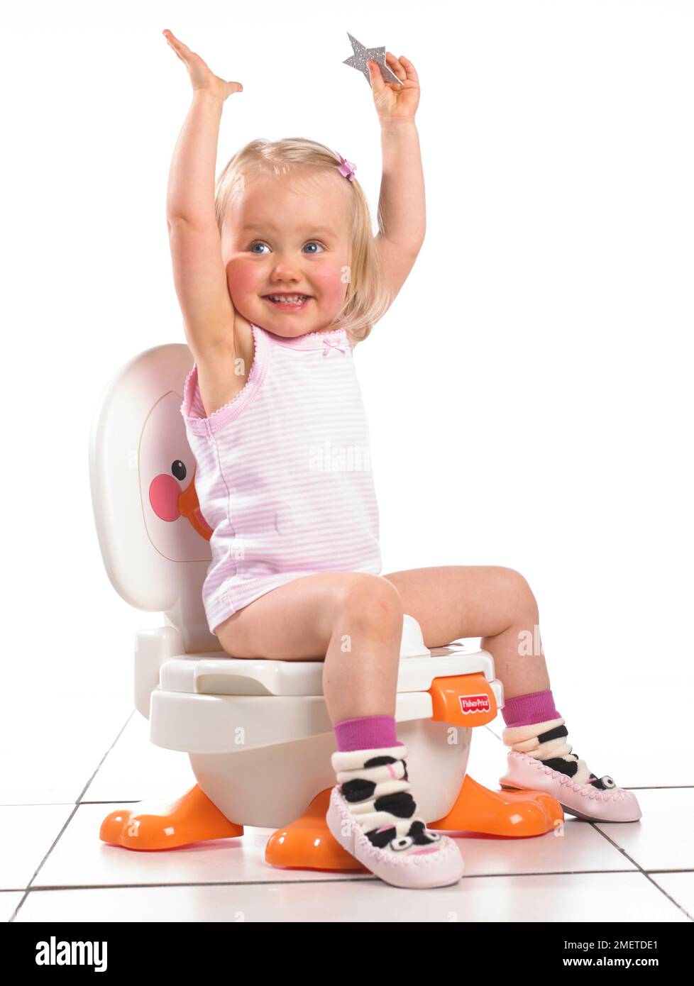 Girl wearing vest sitting on white potty with arms it the air, 20 months Stock Photo - Alamy