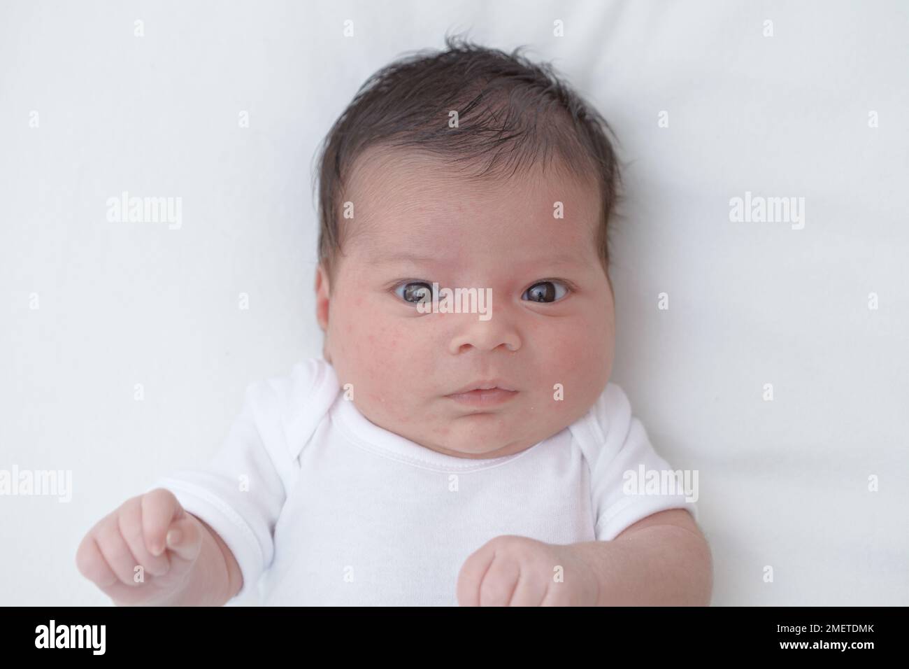 Baby girl lying on her back, looking at camera Stock Photo - Alamy