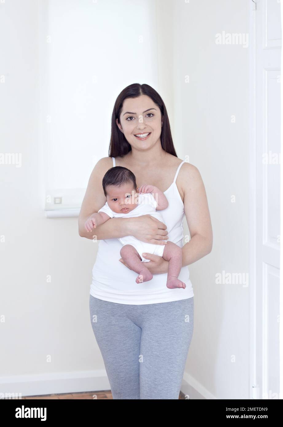 Mother carrying baby girl Stock Photo - Alamy