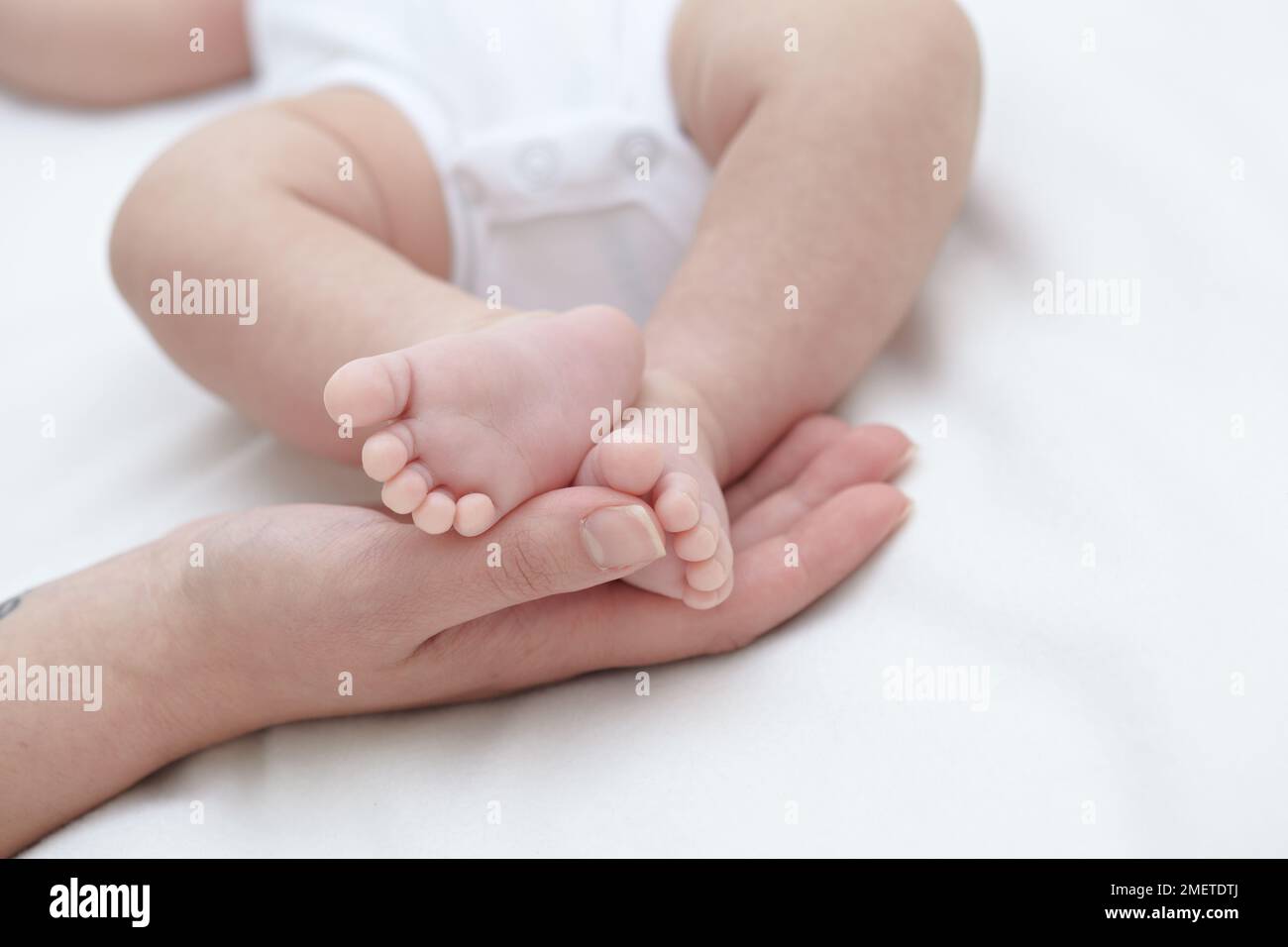 Hand holding baby feet hi-res stock photography and images - Alamy