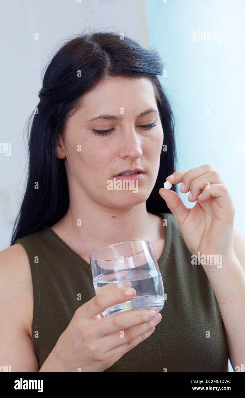 Woman taking medication Stock Photo - Alamy